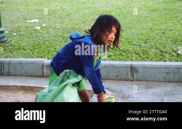 A Little girl Throws Garbage In The Trash In In The Capital Of Cambodia ...