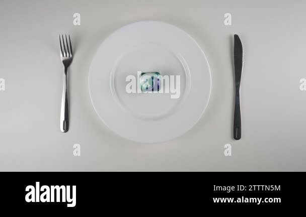 Washing powder pod on a plate, detergent pod. Zoom in. Preparing to eat ...
