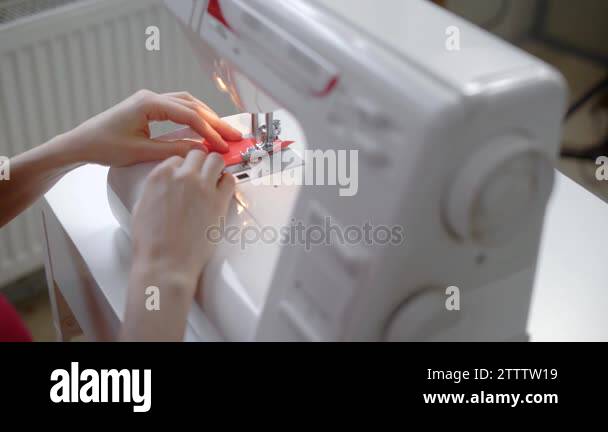Close shot on a womans hands, who works behind an electric sewing ...
