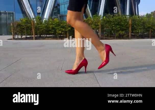 Female legs in high heels shoes walking in the urban street. Feet of ...
