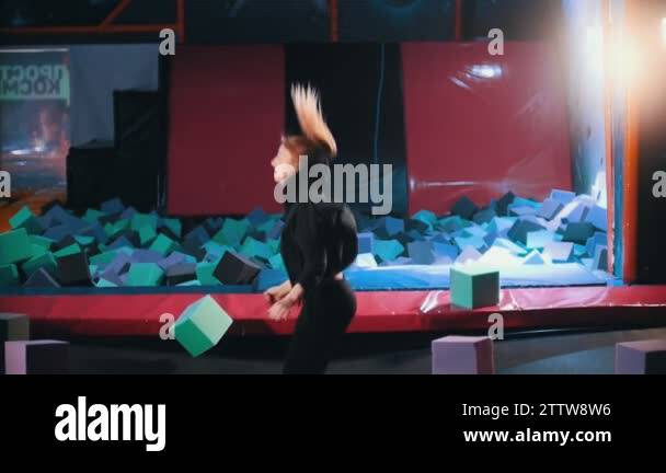 Young sportive woman acrobats perform acrobatic tricks - jumping in a ...