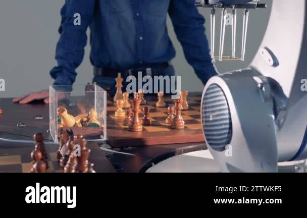 Robot and human competition. Robot hand playing chess with a man ...