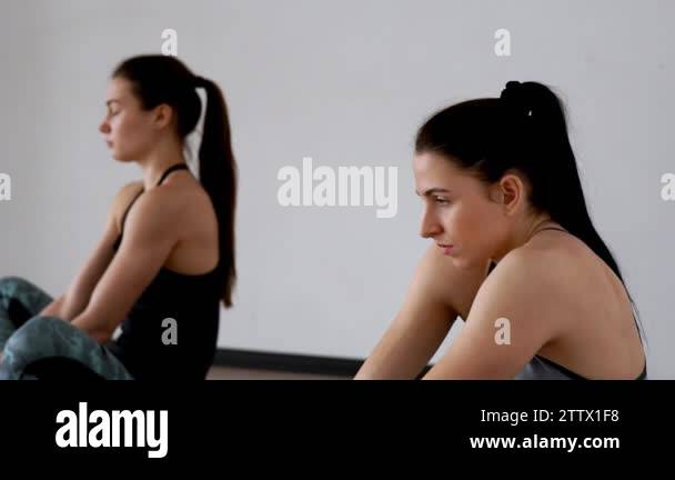 Beautiful girls perform an exercise for posture sitting in a butterfly ...
