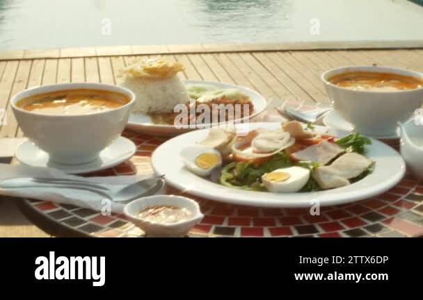 dishes of Thai cuisine. 4k. table by the pool. Thai traditional lunch ...