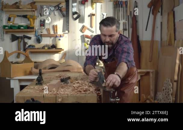Carpenter Planes Solid Wood in his Workshop/Cabinet maker planes the ...