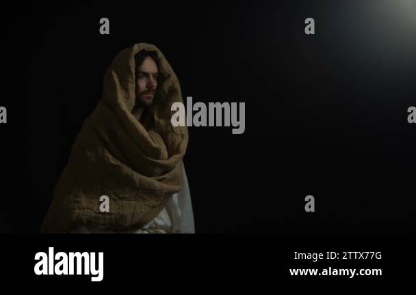 Jesus in robe coming out of darkness and raising hands, appeal to god ...