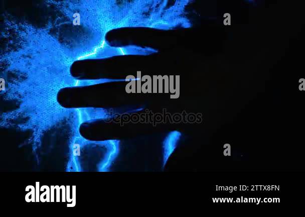 Abstract blue lightning. A man touches his hand to electricity. Aura ...