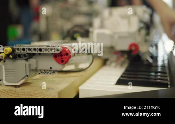 Finger pressing button, robot playing the piano, side view. Machine ...