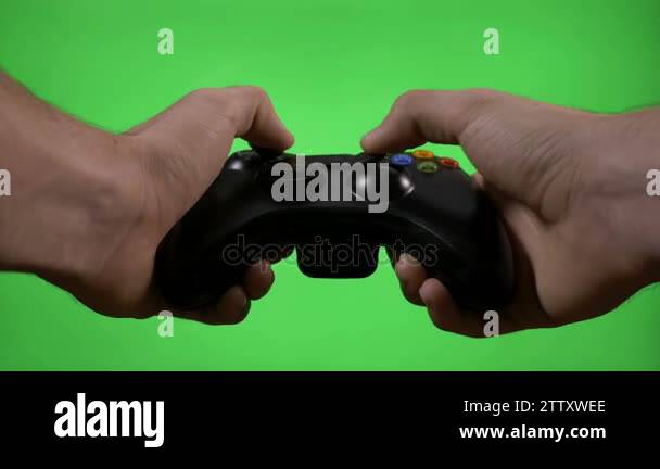 Frustrated angry gamer playing video game match on green screen shaking game remote controller ...