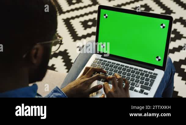 Over shoulder view of the African American man in glasses typing on the ...