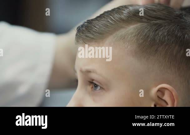 Close up. Barber combs hair of client in the Barbershop with comb ...