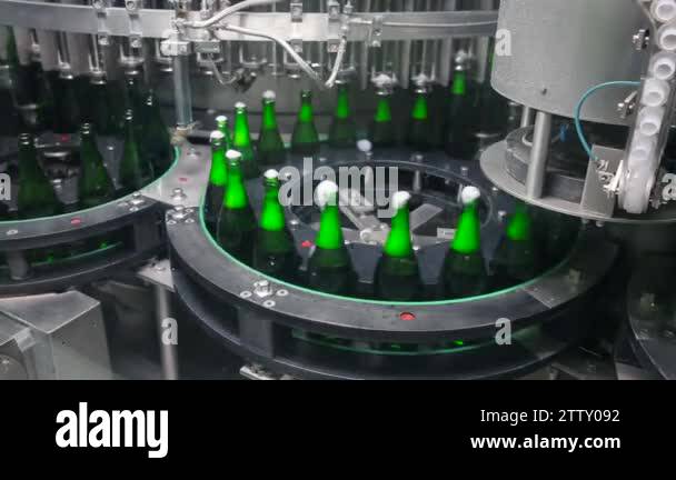 Bottles of green color move along conveyor at the factory of champagne ...