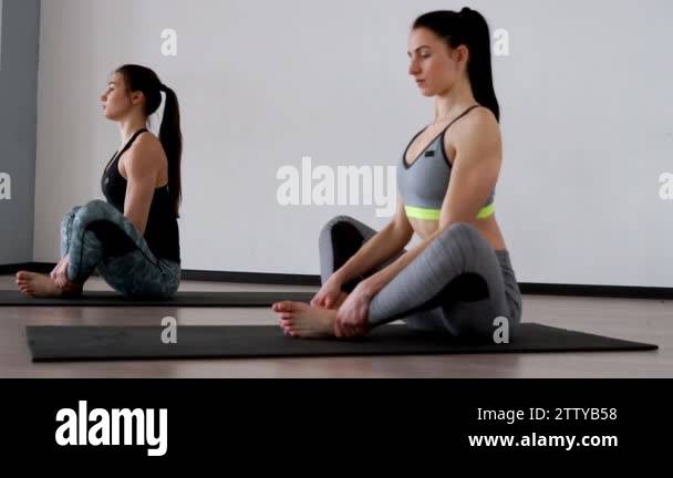 Beautiful girls perform an exercise for posture sitting in a butterfly ...