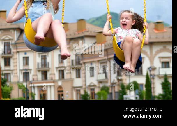 Little girls ride on a swing. Two little sisters enjoy life on the swings Stock Video Footage ...