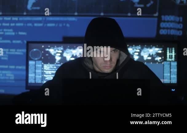 Man Geek Hacker In Hood Working At Computer While Blue Code Characters