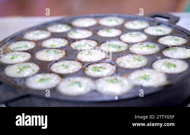 Female cooks the Thailand traditional local dessert (Kanom Krok) with ...