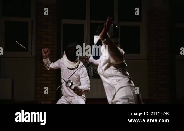 Young man and woman in hats and costumes for fencing battle on the foil ...