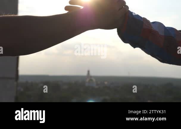 Close up of two friends meeting on rooftop and having a firm friendly ...