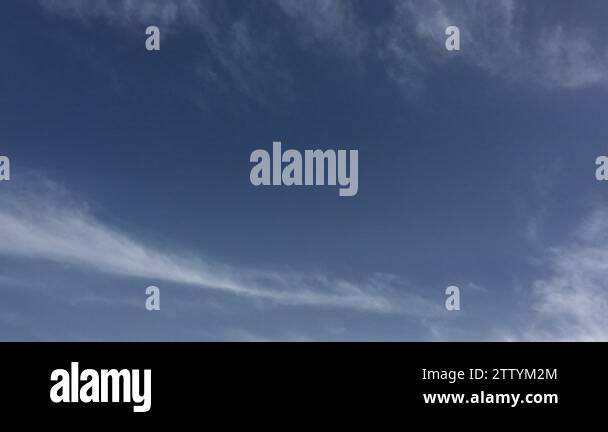 White clouds disappear in the hot sun on blue sky. Time-lapse motion ...