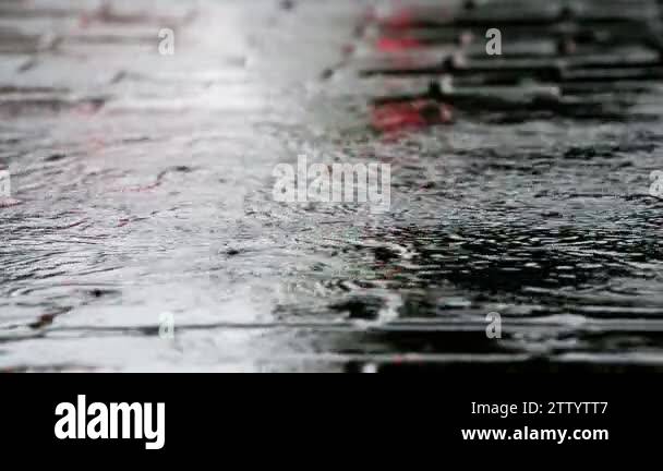 Rainwater Streams on the Sidewalk. Drops of rain fall on the paving ...