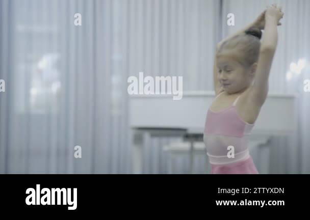 The portrait of girl with raised hands who exercises how to turn around ...