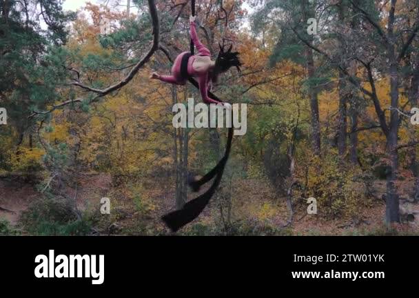 Woman acrobat hanging on the aerial silk and shows a show of air ...