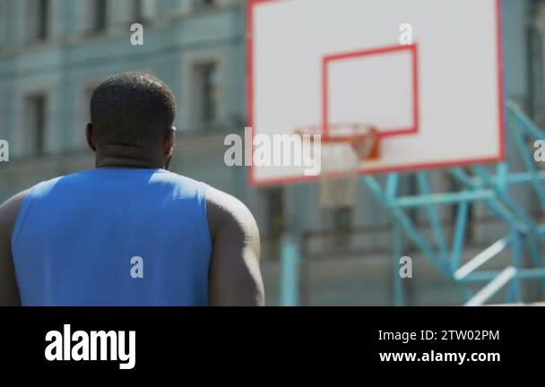 Back view of basketball player practicing free throws outdoors, active ...