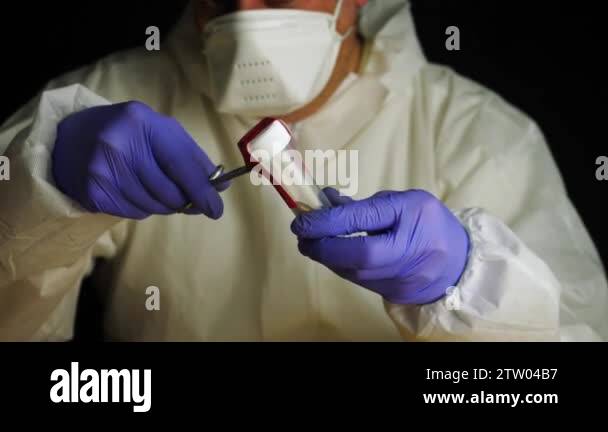 Expert police officer examines with magnifying glass a bullet in ...