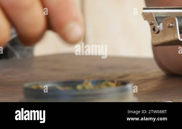 Mens hands make handmade cigarette or roll-ups with roll-up machine ...