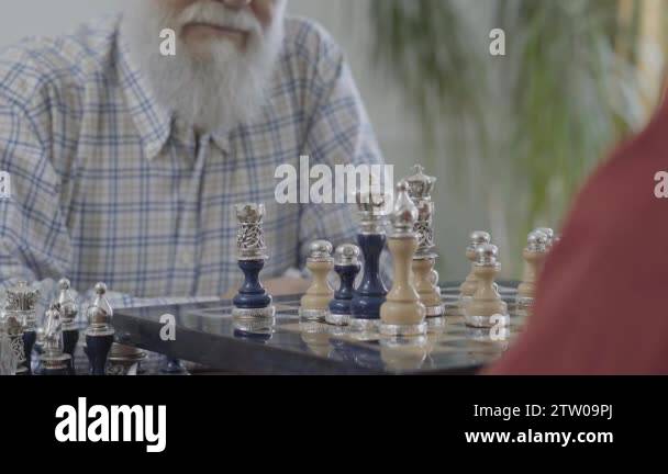 Hand of unrecognizable man lays down a chess piece. Two men shaking ...