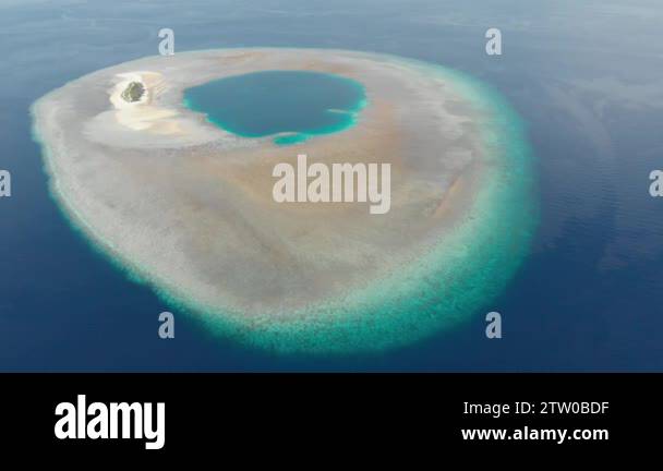 Aerial: Flying over idyllic atoll, travel destination Wakatobi National ...