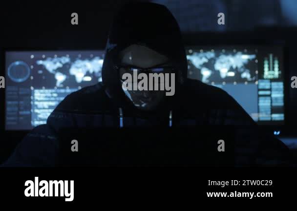 Man Geek Hacker In Hood With Glasses Working At Computer While Blue