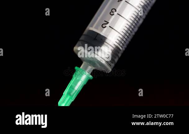 Taking vaccine into a glass syringe from a ampule on a black background ... Taking vaccine into a glass syringe from a ampule on a black background ...
