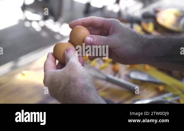 Chef hand breaking chicken eggs on kitchen. Cook break fresh chicken egg for cooking breakfast ...