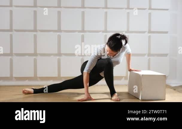 Athletic woman does a forward lunge and turns her body aside to stretch ...