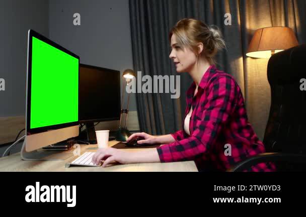 Woman works on her computer, works in office. Monitor green screen ...