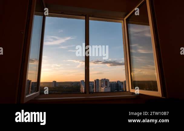 Sunset clouds through a window with a reflection in the window casement. Video. UltraHD (4K ...