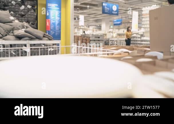 Young Asian woman rides shopping cart choosing new furniture in ...