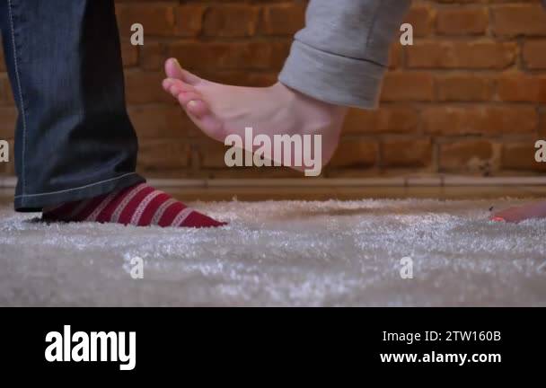 Close-up shot of female and male trying to step on the feet of each ...