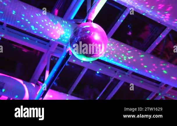 Disco ball rotates under the ceiling in a nightclub, glitters and ...