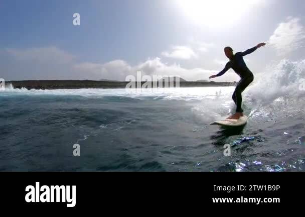 SLOW MOTION: Fit surfer catching last waves of the day on his cool ...