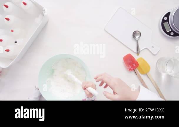 Flat lay. Step by step. Mixing royal icing to decorate sugar cookies ...