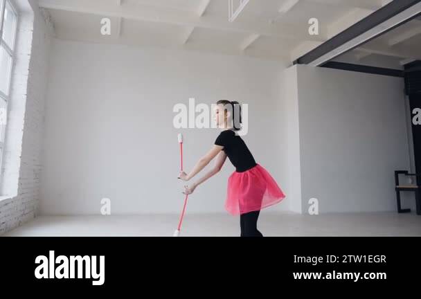 Girl gymnast rotates maces. Girl gymnast with mace in hand revolve ...