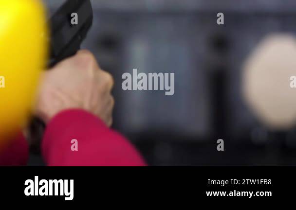 Back view of man shoots a gun at shooting range close up. Man fires ...
