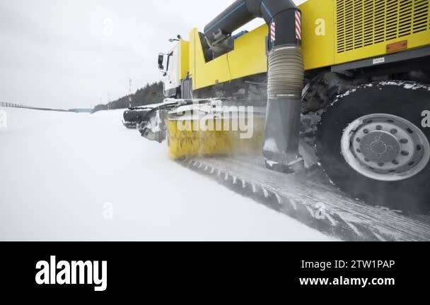 Heavy wheel machinery removes snow from the road with big massive ...