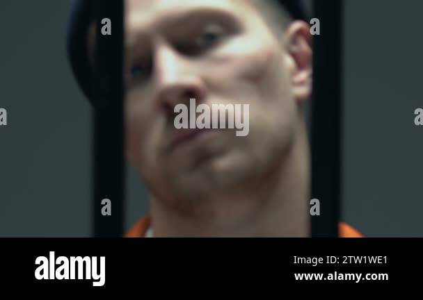 Mad maniac with scars on face holding prison bars and screaming, mental ...