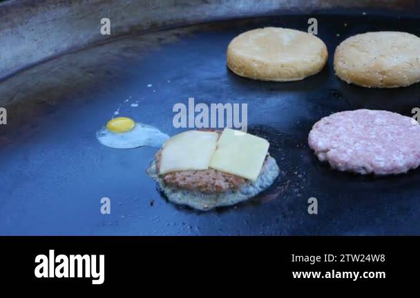 Cook uses a blow torch to melt cheese on a meat cutlet. Chef melts ...