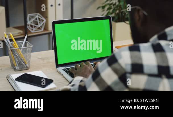 Over shoulder view on the African American man working and taping on ...