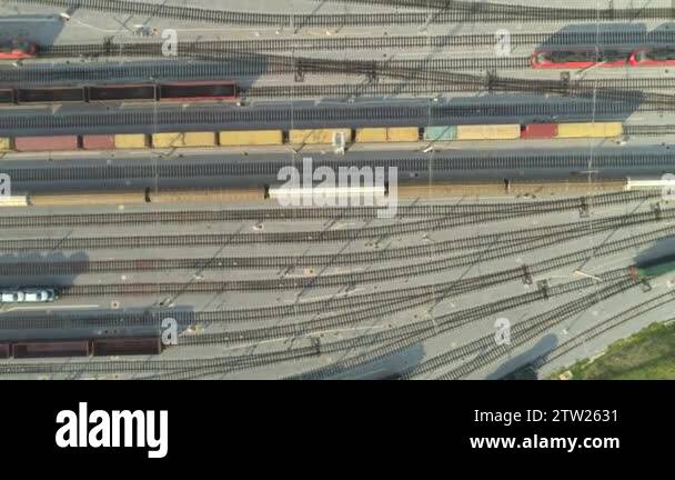 AERIAL TOP DOWN: Flying above loaded cargo train wagons leaving ...