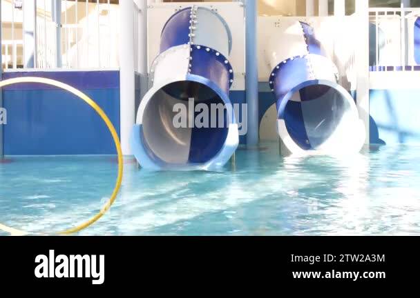 children swim in the pool, roll down from the water slide 4k, slow ...